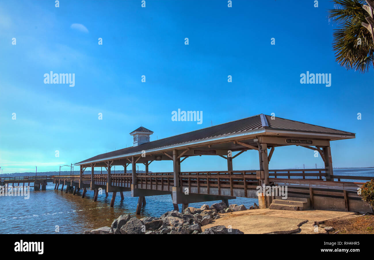 An old fishing pier on St Simons Island beyond rock seawall Stock Photo ...