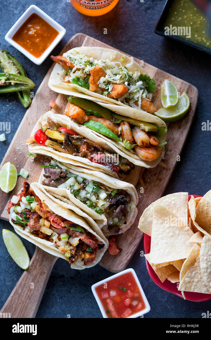 taco sampler on wooden board with tortilla chips and salsa Stock Photo ...