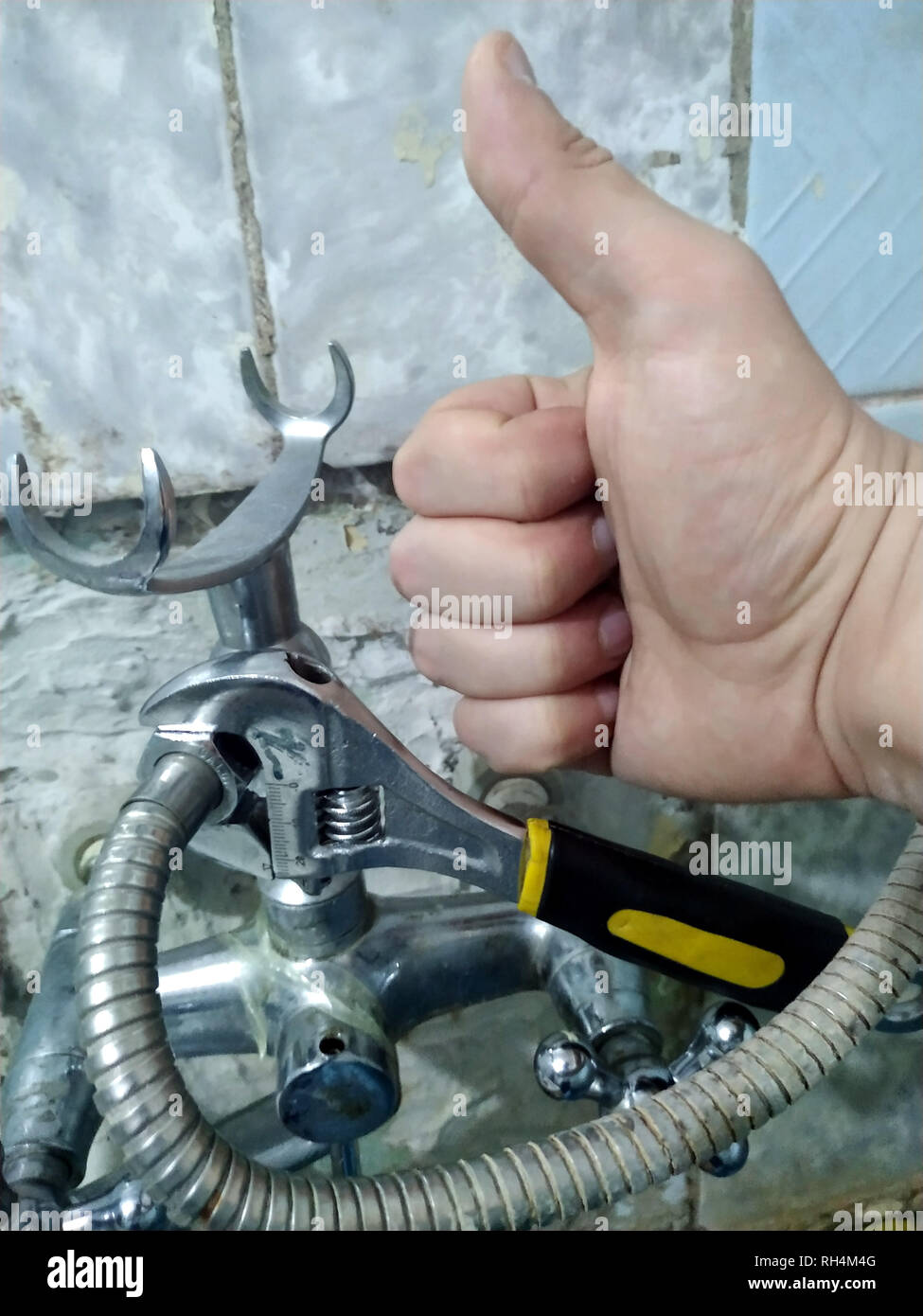 Fix a leaking tap, close-up hand showing thumbs up sign Stock Photo - Alamy
