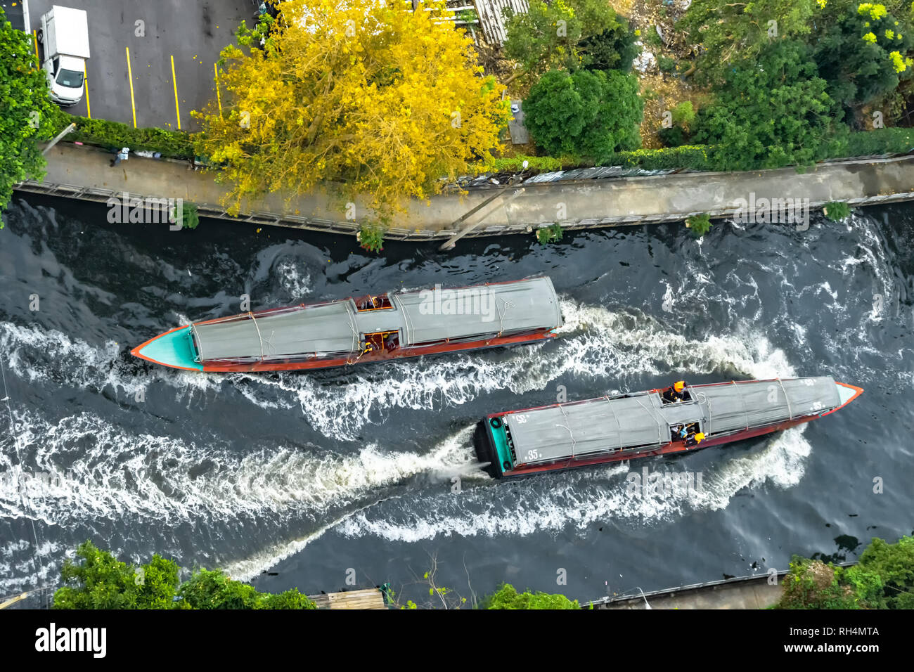 Arial view of two water buses passing each other on a canal in Bangkok ...
