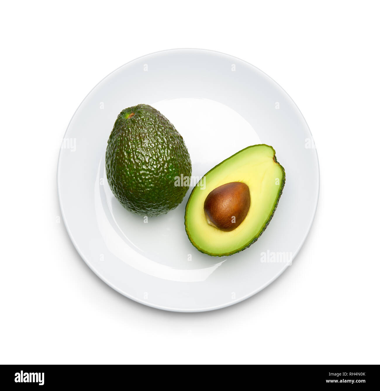 Avocado on plate over white background, top view Stock Photo - Alamy