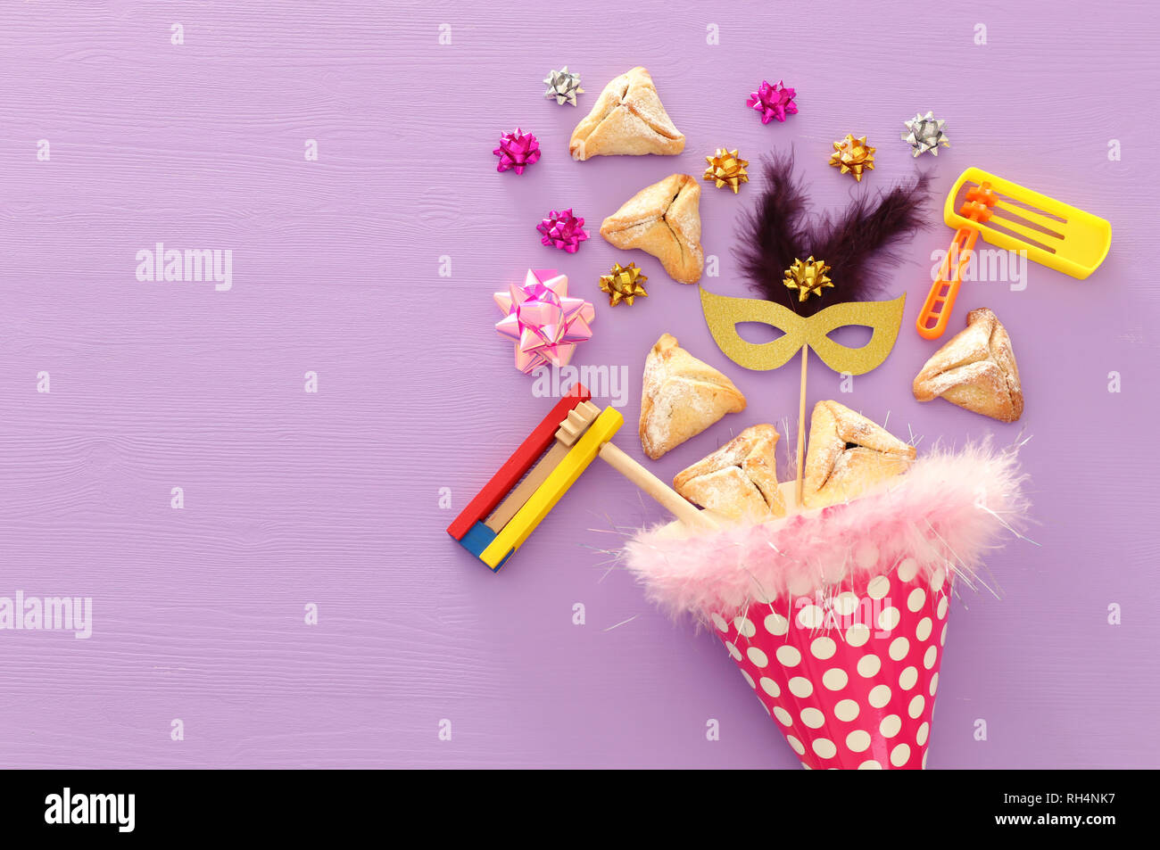 Purim celebration concept (jewish carnival holiday) over wooden purple ...