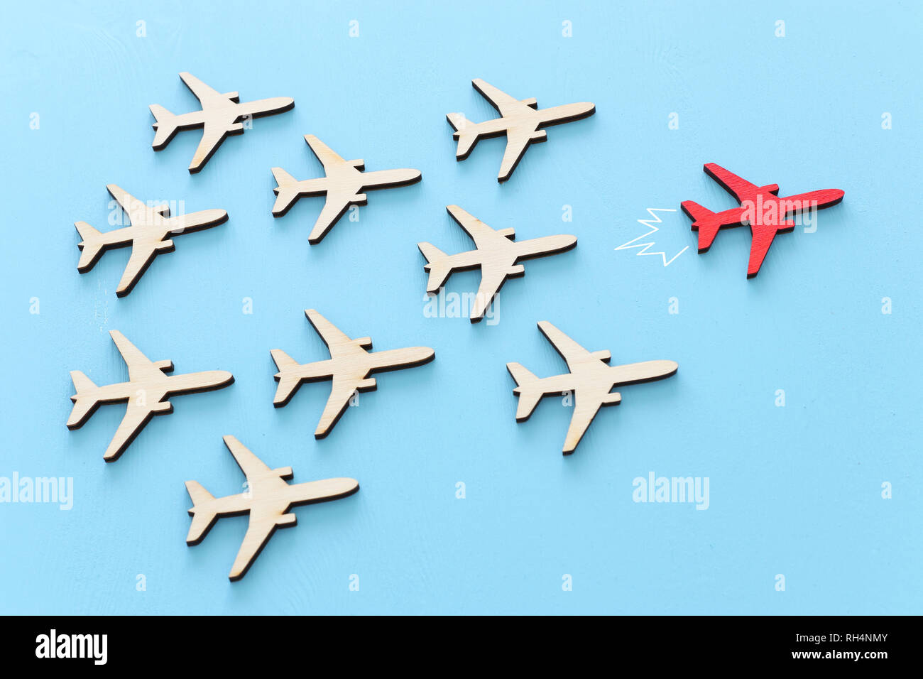 Leadership concept with airplanes on blue wooden background. One red ...