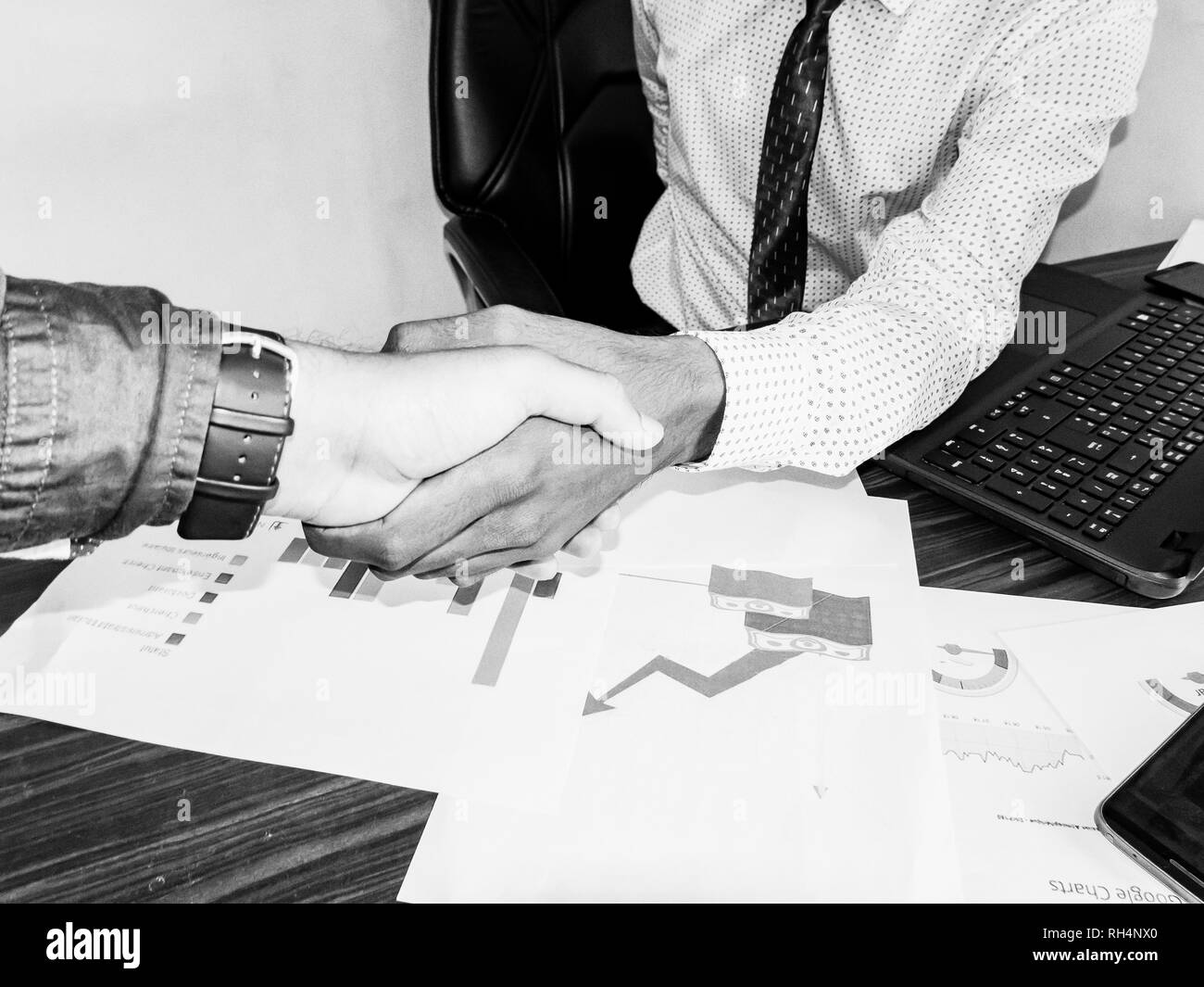 Aerial view of two indian men sitting at the desk with graphs sheets on ... Aerial view of two indian men sitting at the desk with graphs sheets on ...