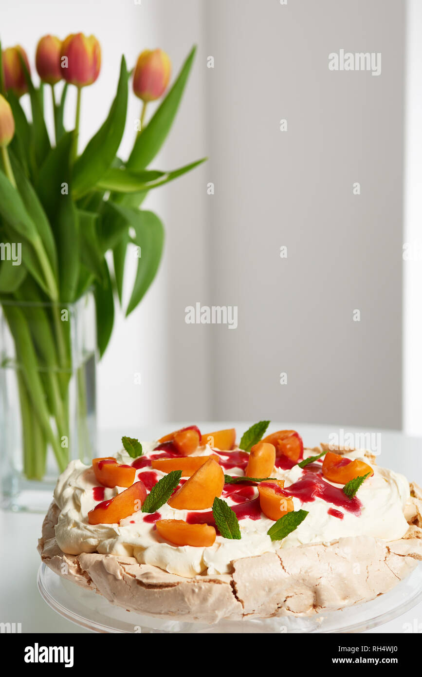 Homemade apricot pavlova with rasberry coulis and mint leaves Stock ...