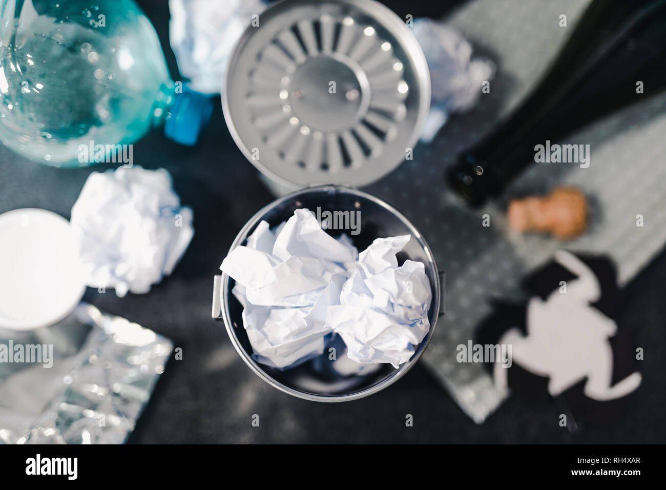 full trash can surrounded by reusable waste materials like plastic ...