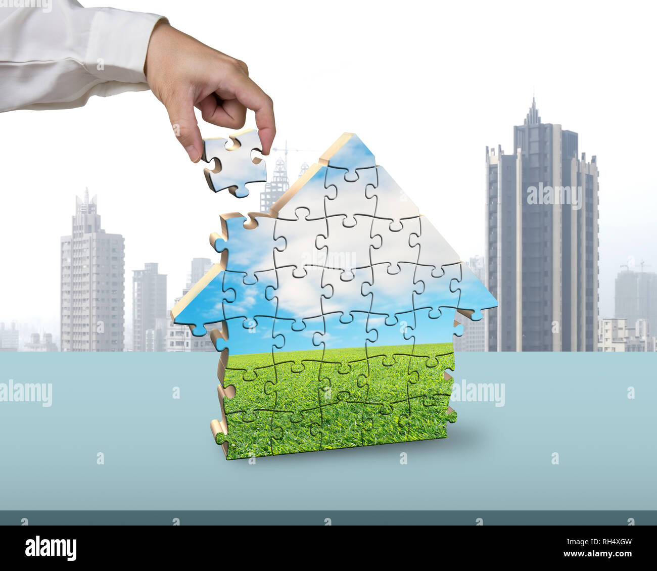 Assembling puzzles in house building shape in office Stock Photo - Alamy