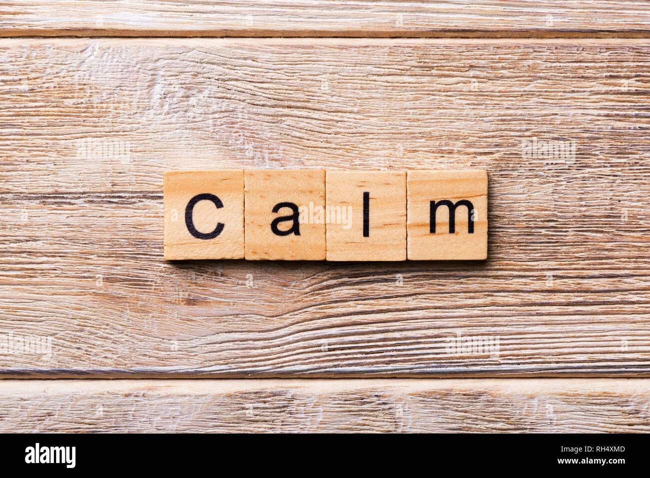 calm word written on wood block. calm text on wooden table for your ...