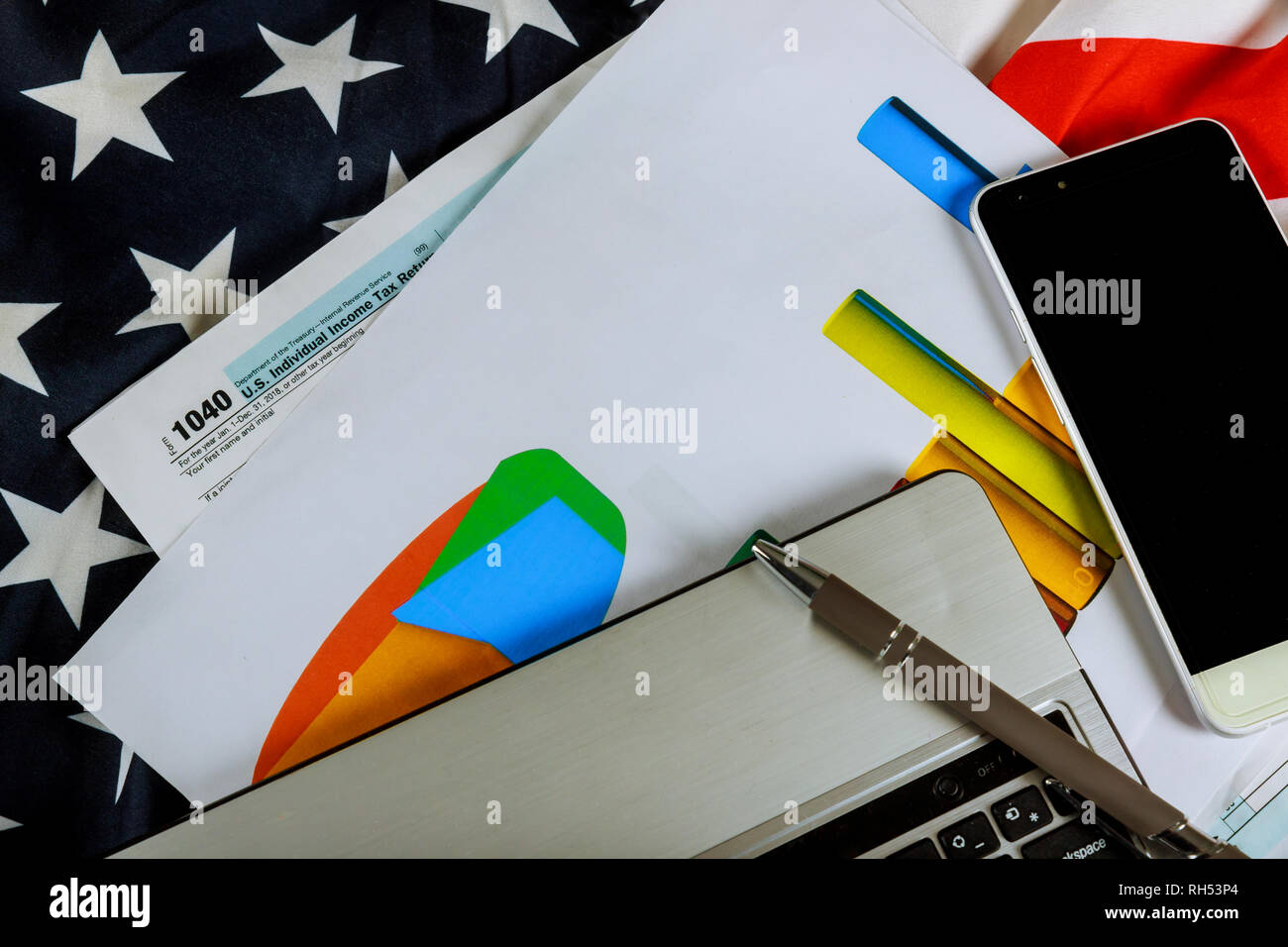 Top veiw USA IRS tax form 1040 and a U S flag selective soft focus ...