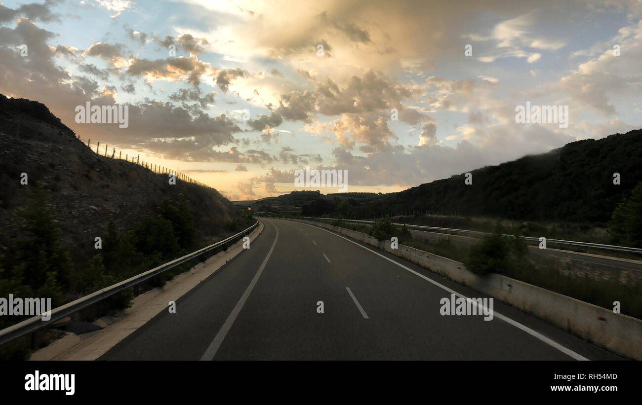 Road view in the evening with some clouds Stock Photo - Alamy