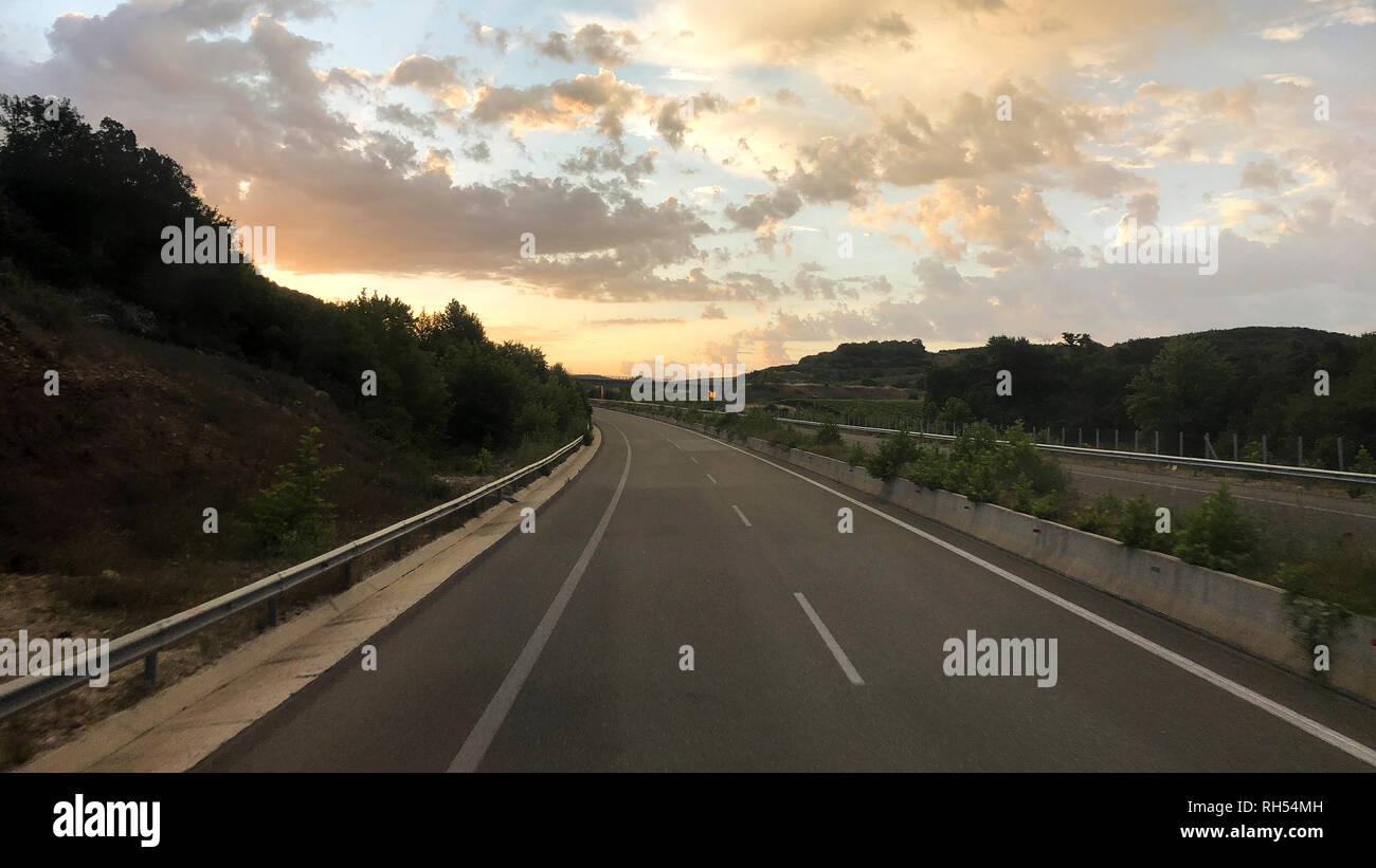 Road view in the evening with some clouds Stock Photo - Alamy