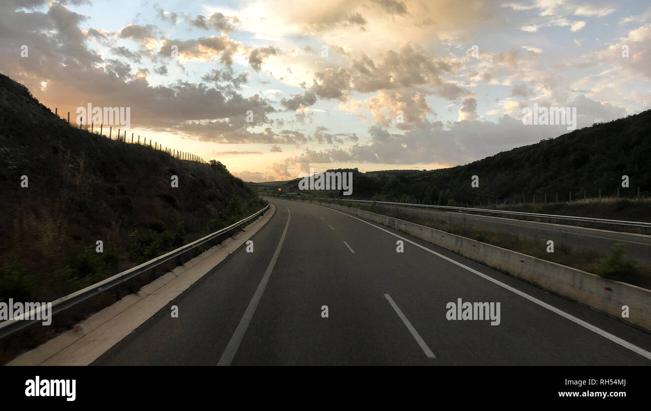 Road view in the evening with some clouds Stock Photo - Alamy