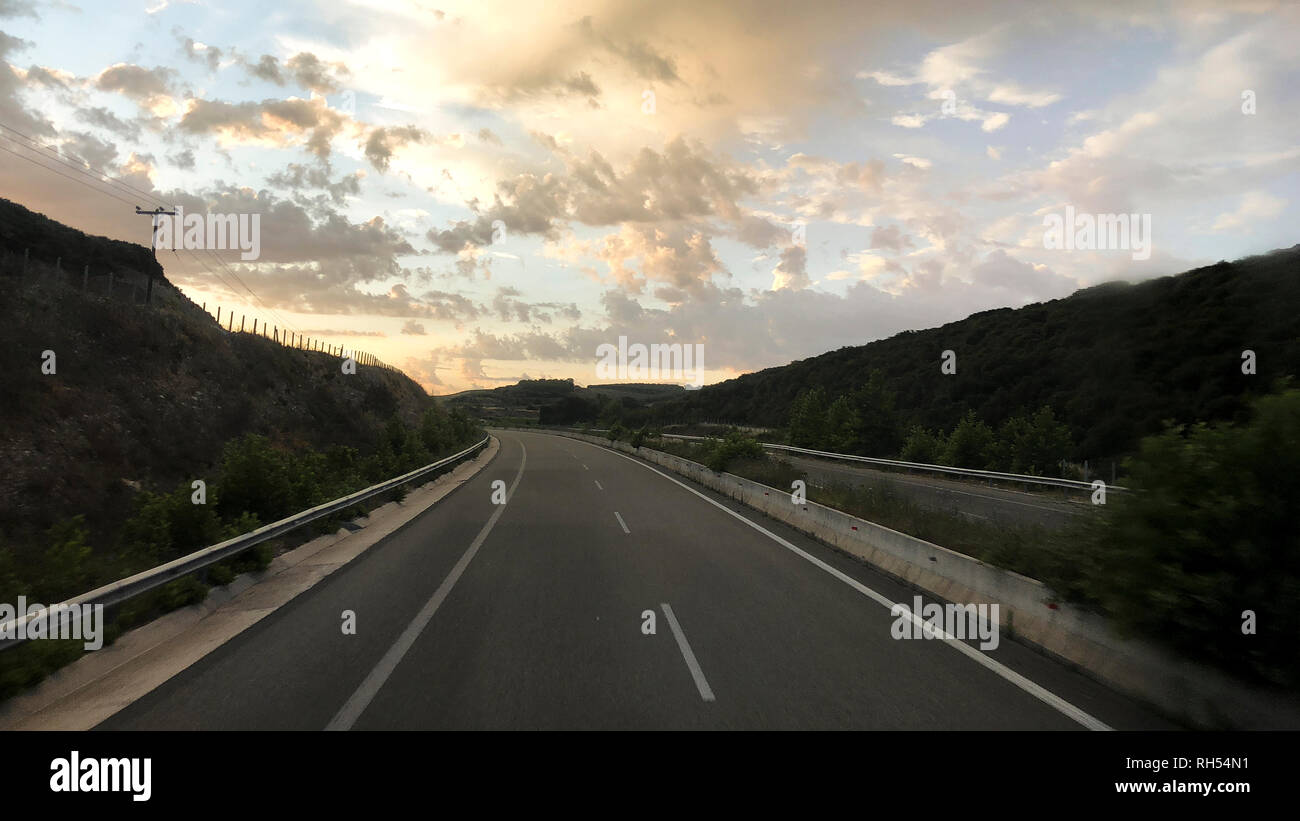 Road view in the evening with some clouds Stock Photo - Alamy