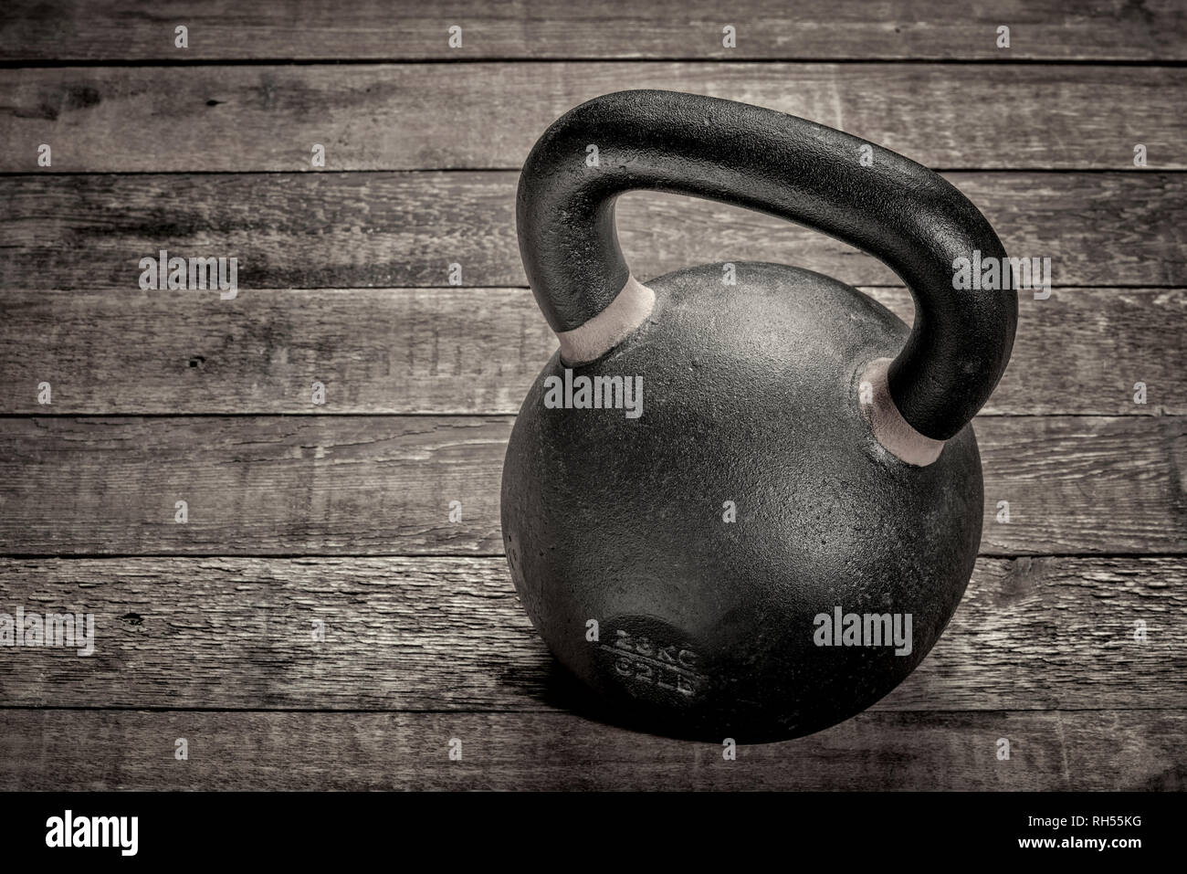 heavy iron kettlebell on a rustic wood background with a copy space ...