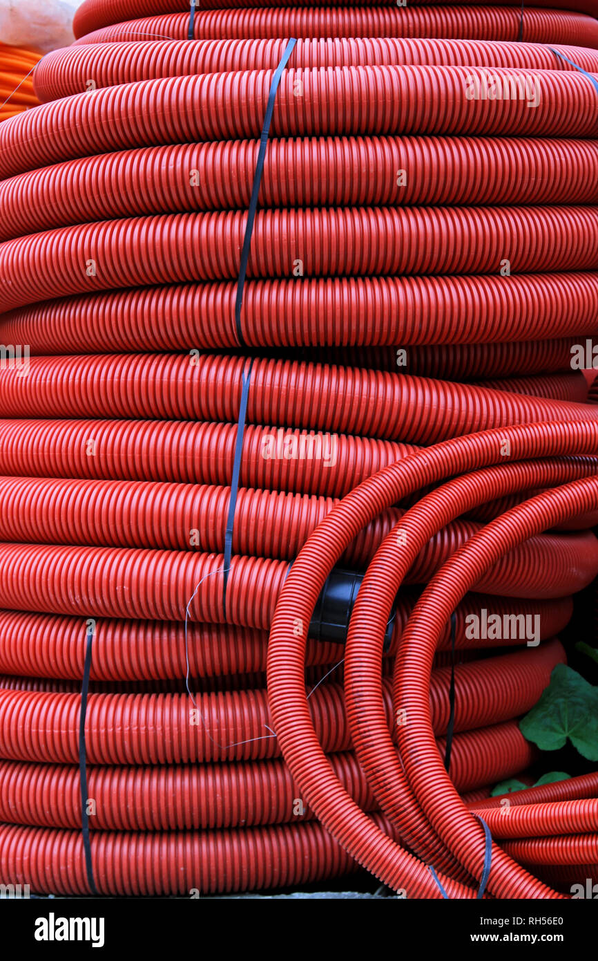 Big pile of red plastic cables in coils Stock Photo - Alamy