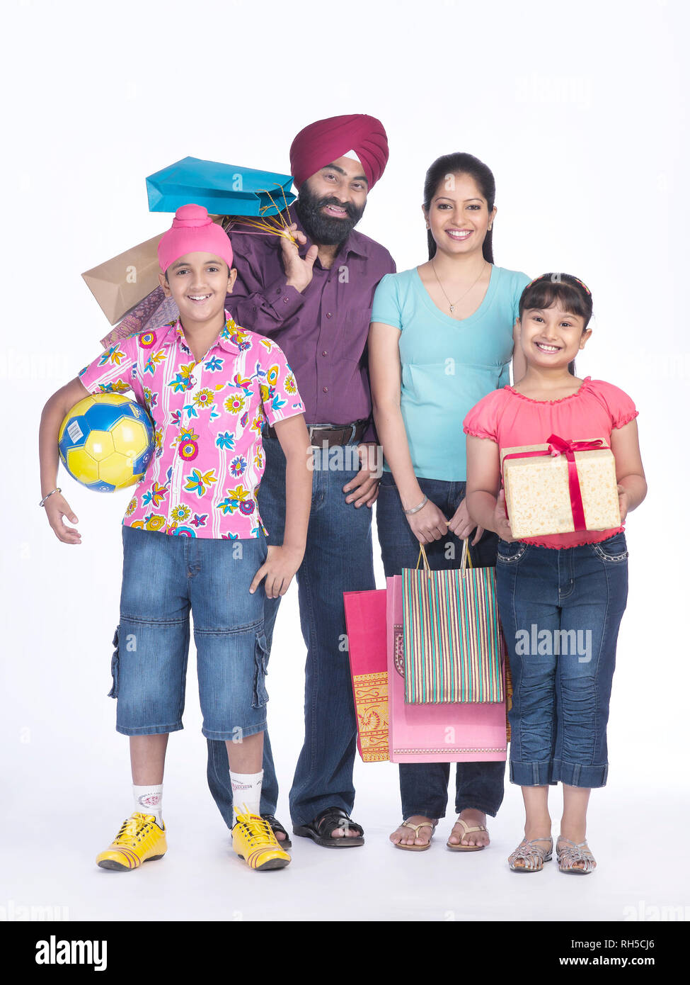 PORTRAIT OF A SIKH SARDAR FAMILY OF FOUR WITH SHOPPING BAGS AND GIFTS ...