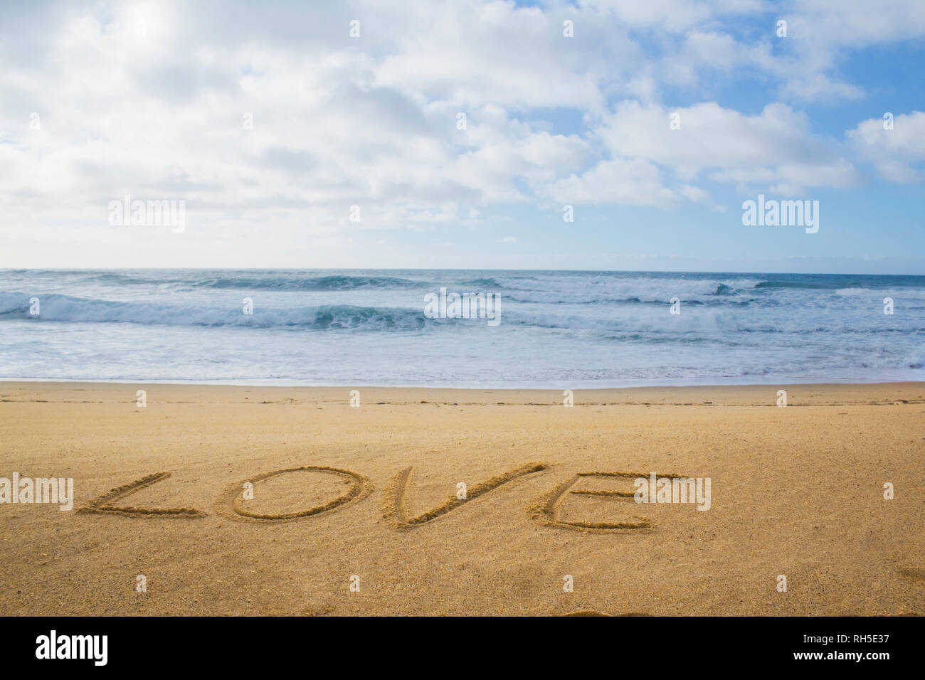 word love written on sand on the beach near the ocean in Portugal Stock ...