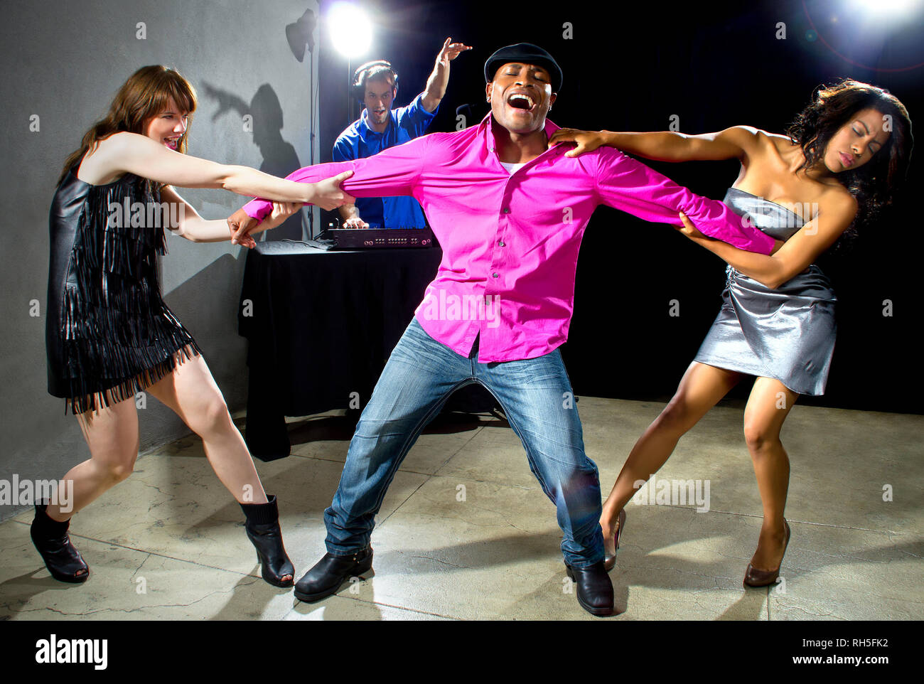 female rivals pulling and grabbing a man in a nightclub Stock Photo - Alamy