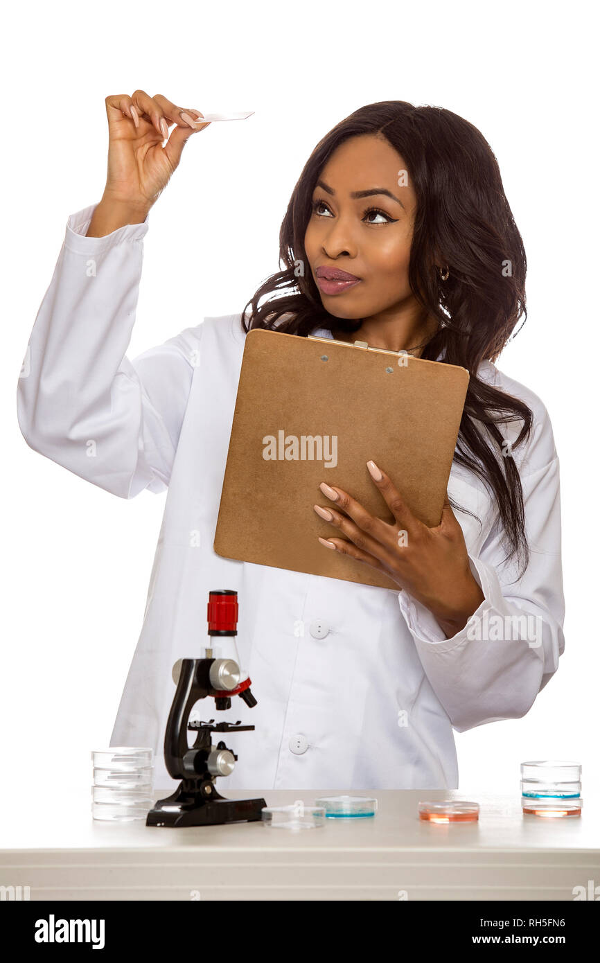Black female scientist wearing a lab coat with microscope and petri ...