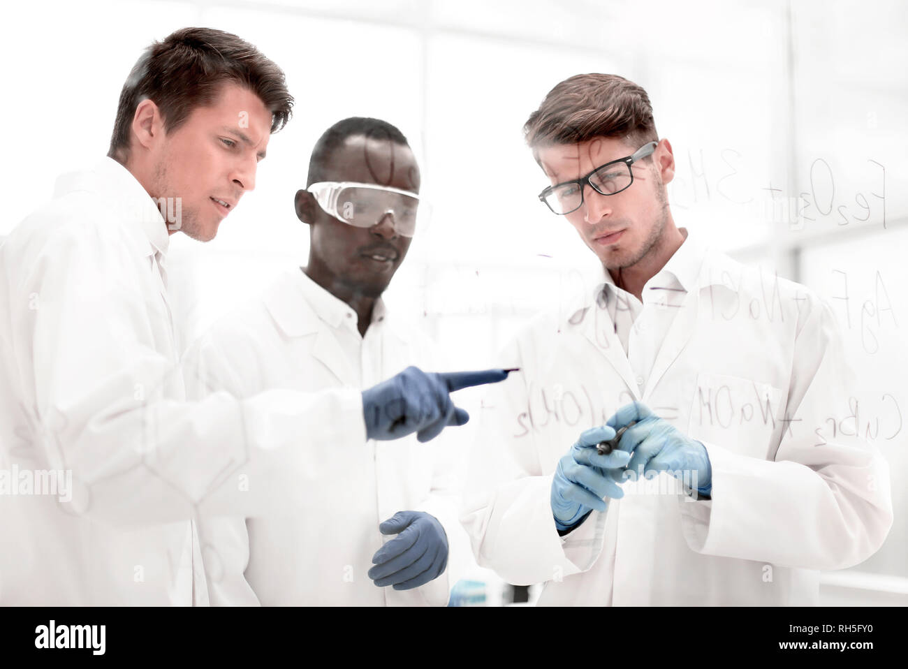 group of scientists discussing chemical formulas Stock Photo - Alamy