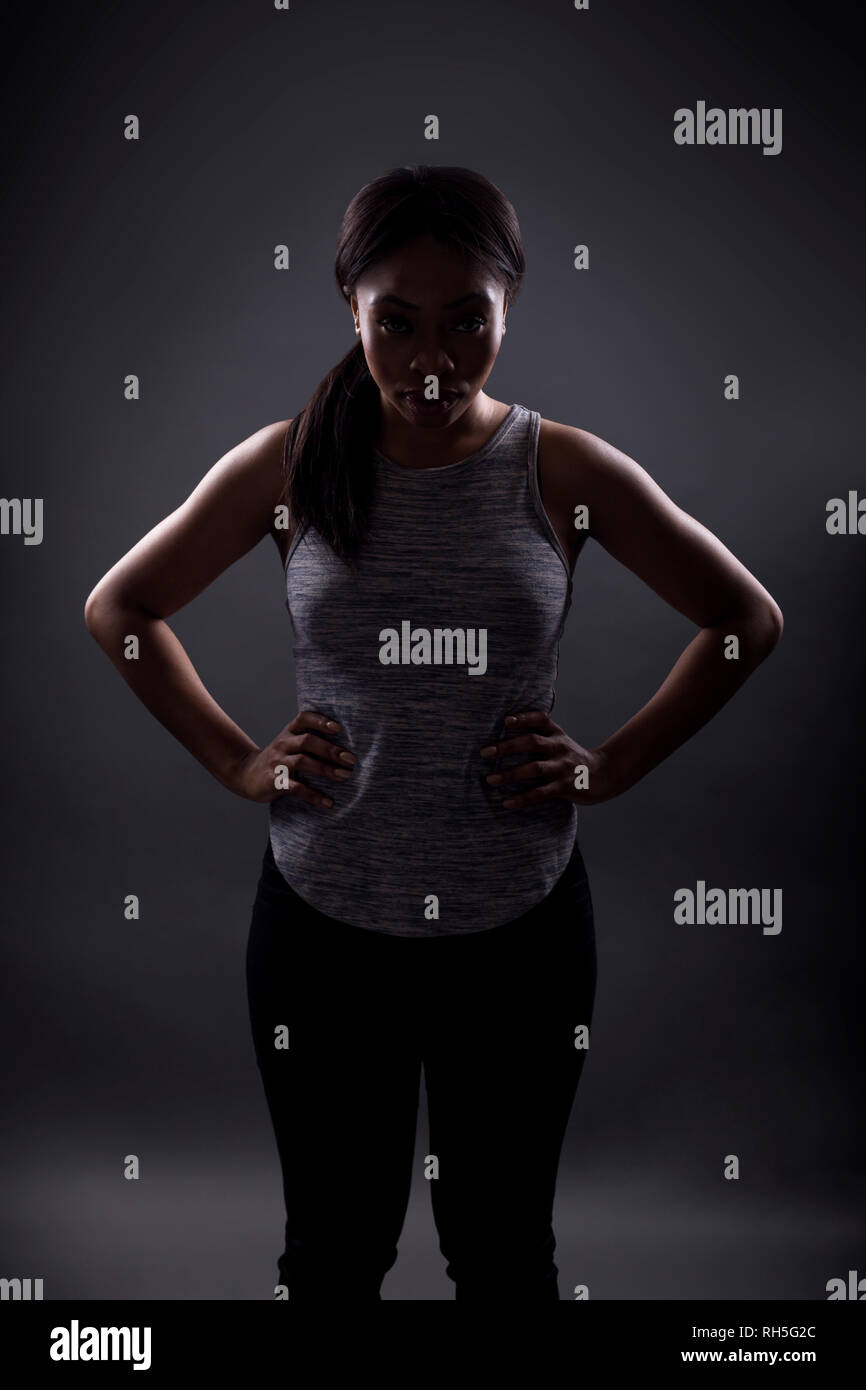 Silhouette of black female in an angry pose or portrait of an athlete ...