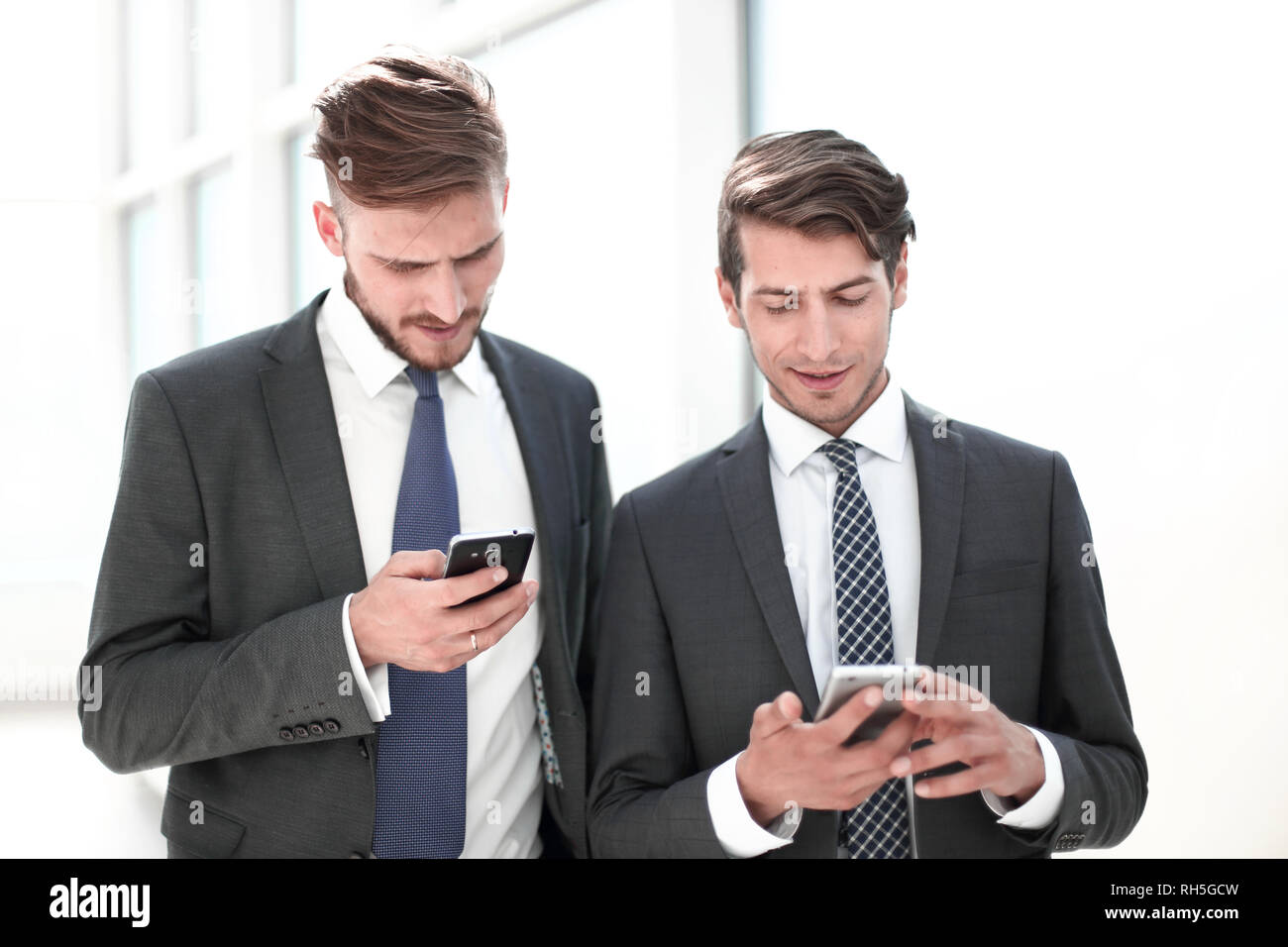 close up.young employees using their smartphones Stock Photo - Alamy