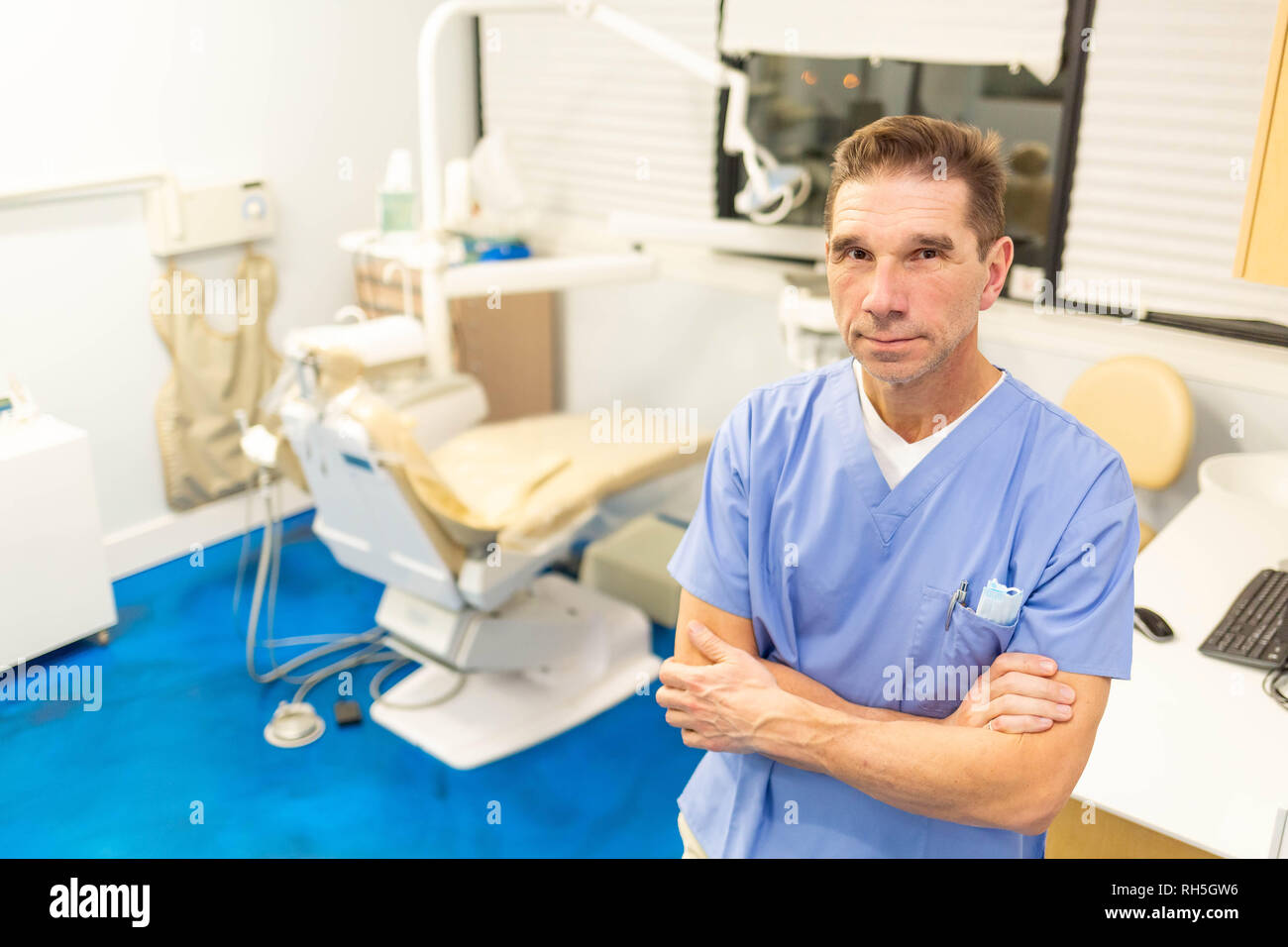 Professional male dentist smiling at camera in dental office Stock ...