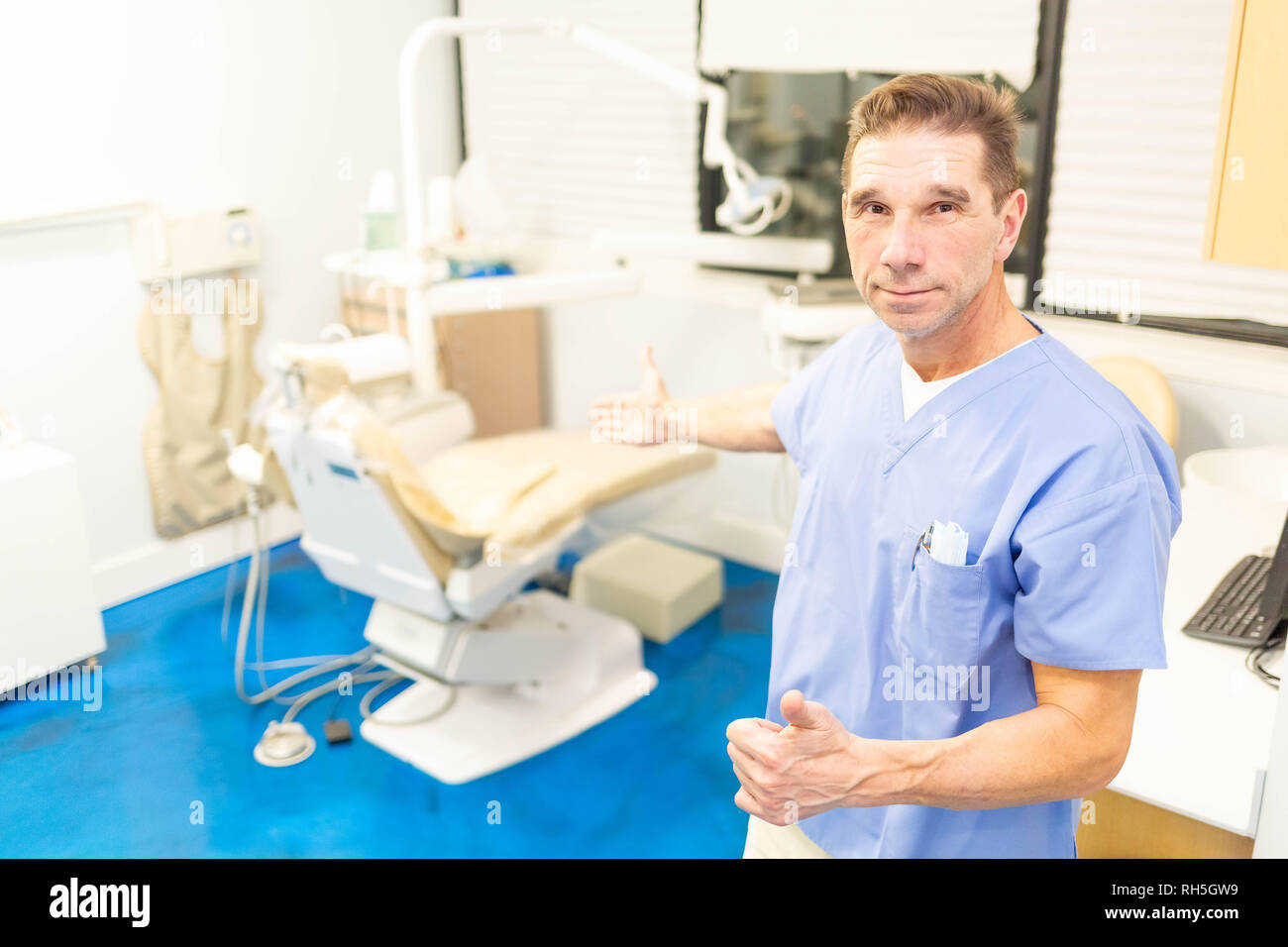 Professional male dentist smiling at camera in dental office Stock ...