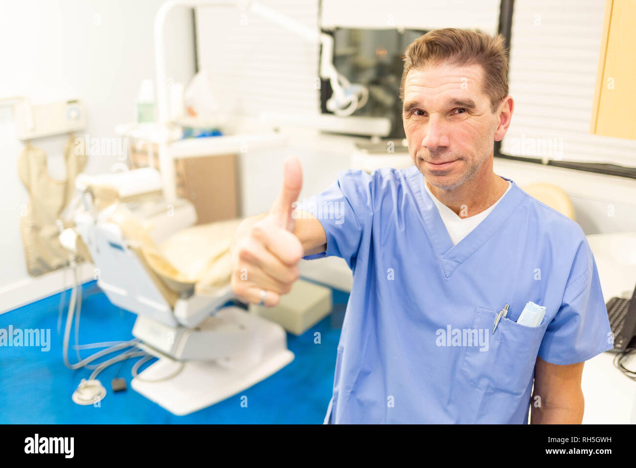 Professional male dentist smiling at camera in dental office Stock ...