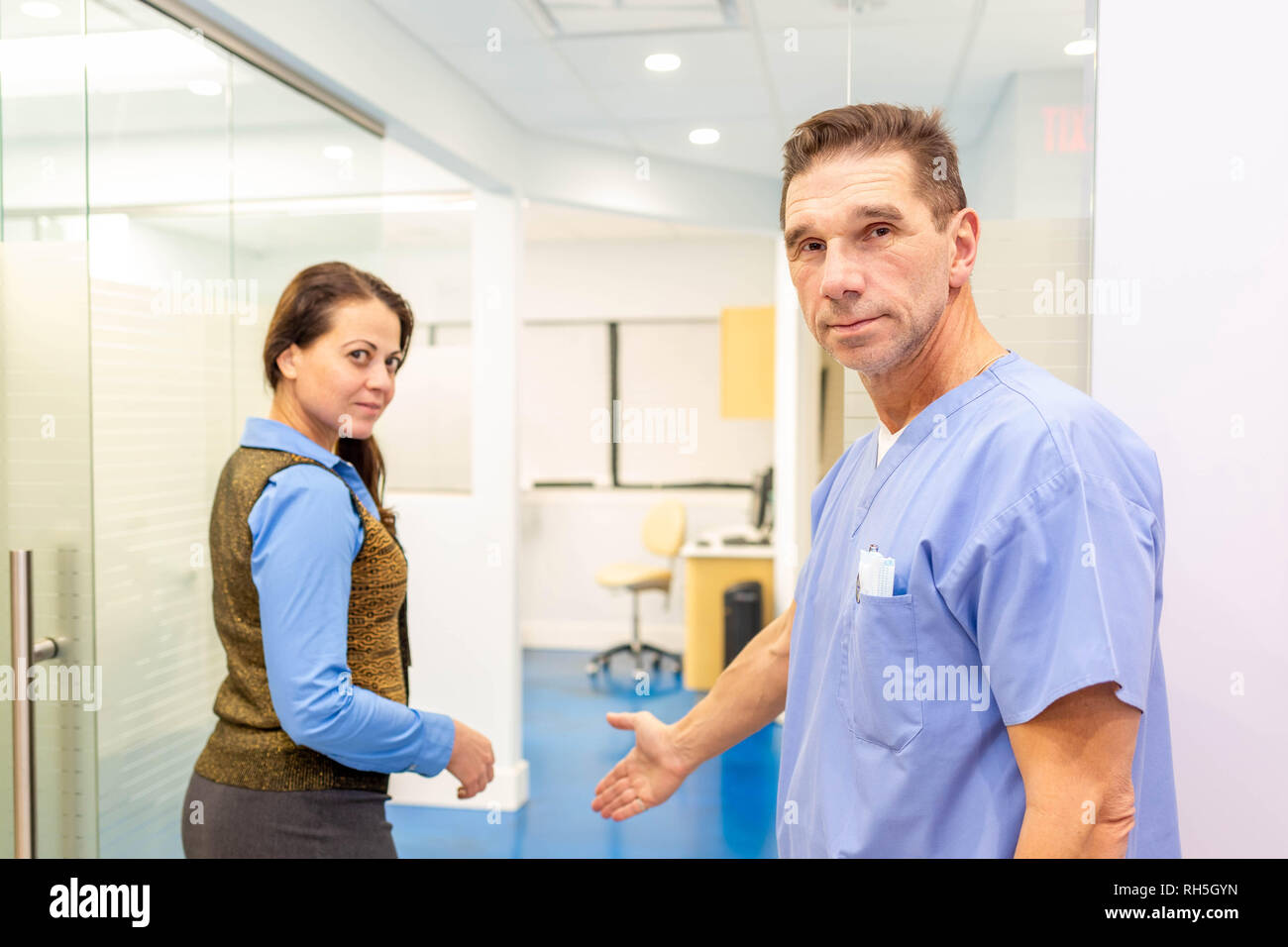 Doctor greets female patient at hospital office welcomes inside Stock ...