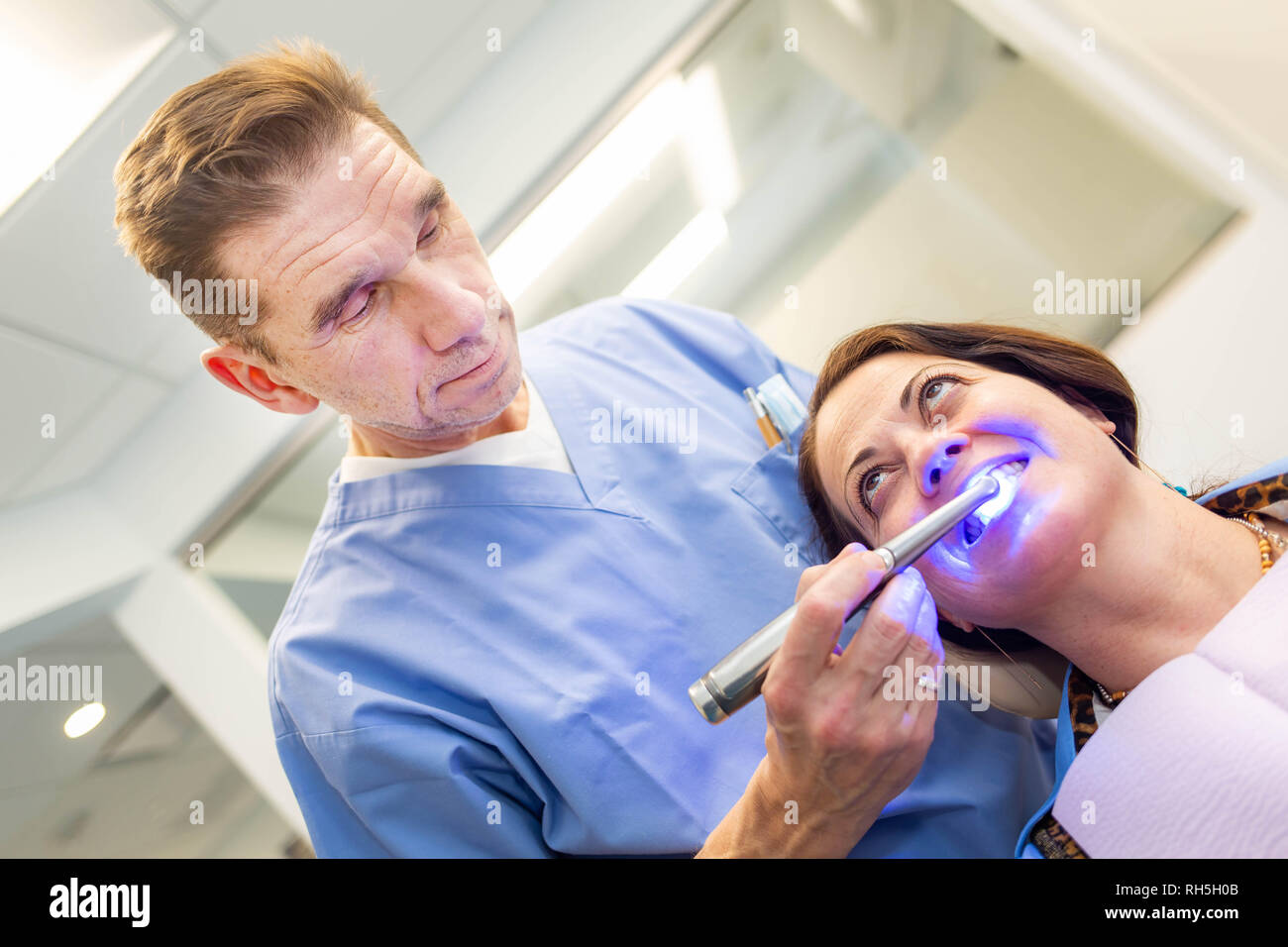 female patient at dentis teeth whitening procedure with ultraviolet ...