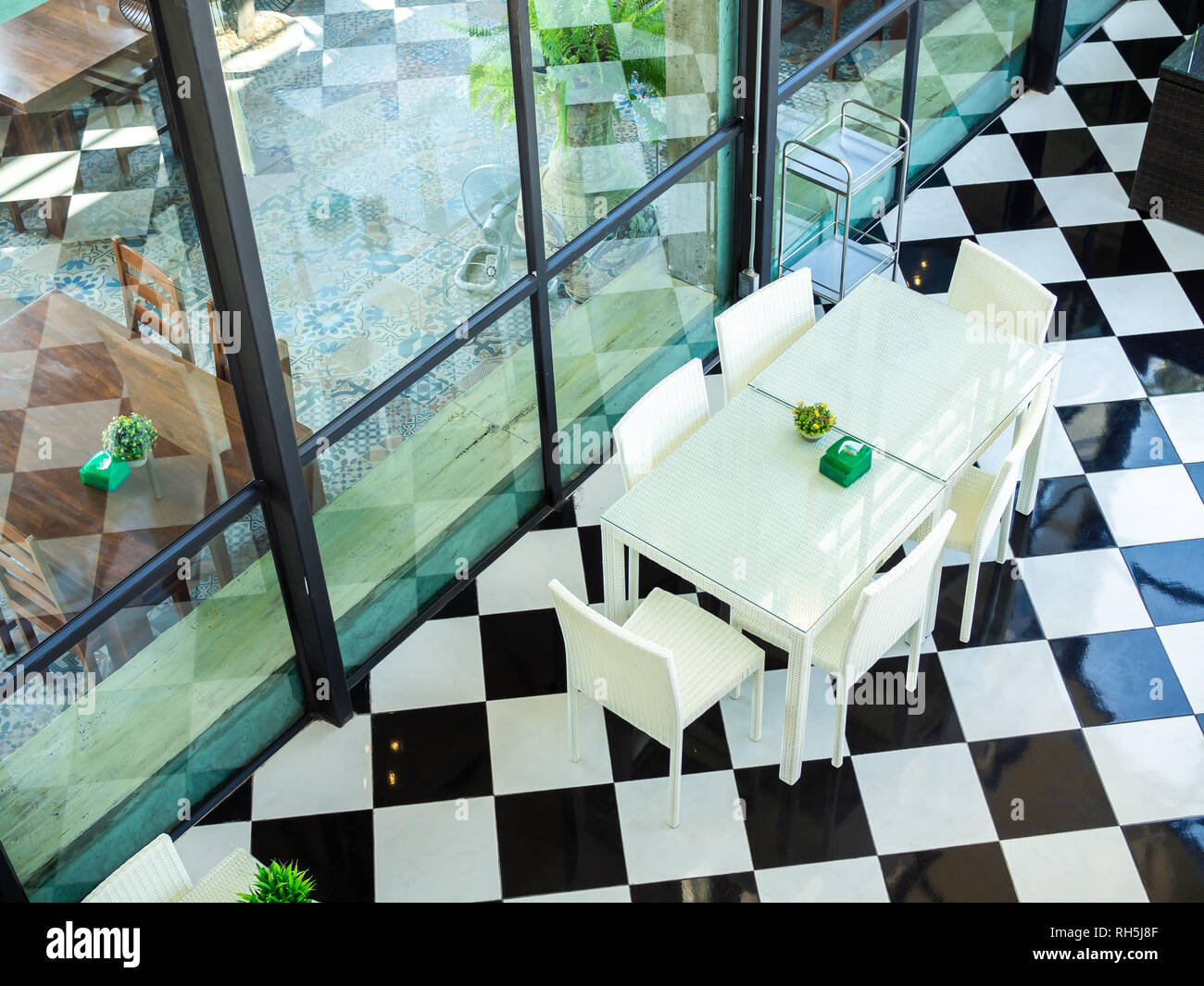 Top view of white weave chairs and white glass table on black and white ...