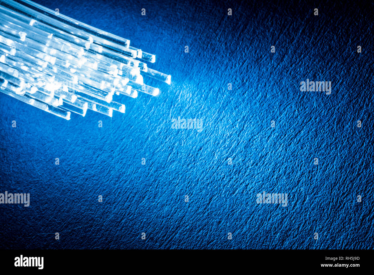 Bundle of optical fibers with lights in the ends. Blue background Stock ...