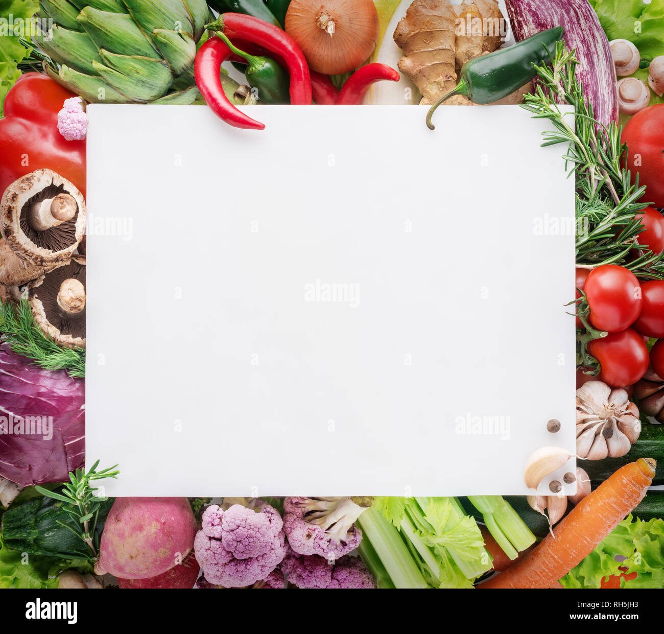 Different colorful vegetables arranged as a frame on white background ...