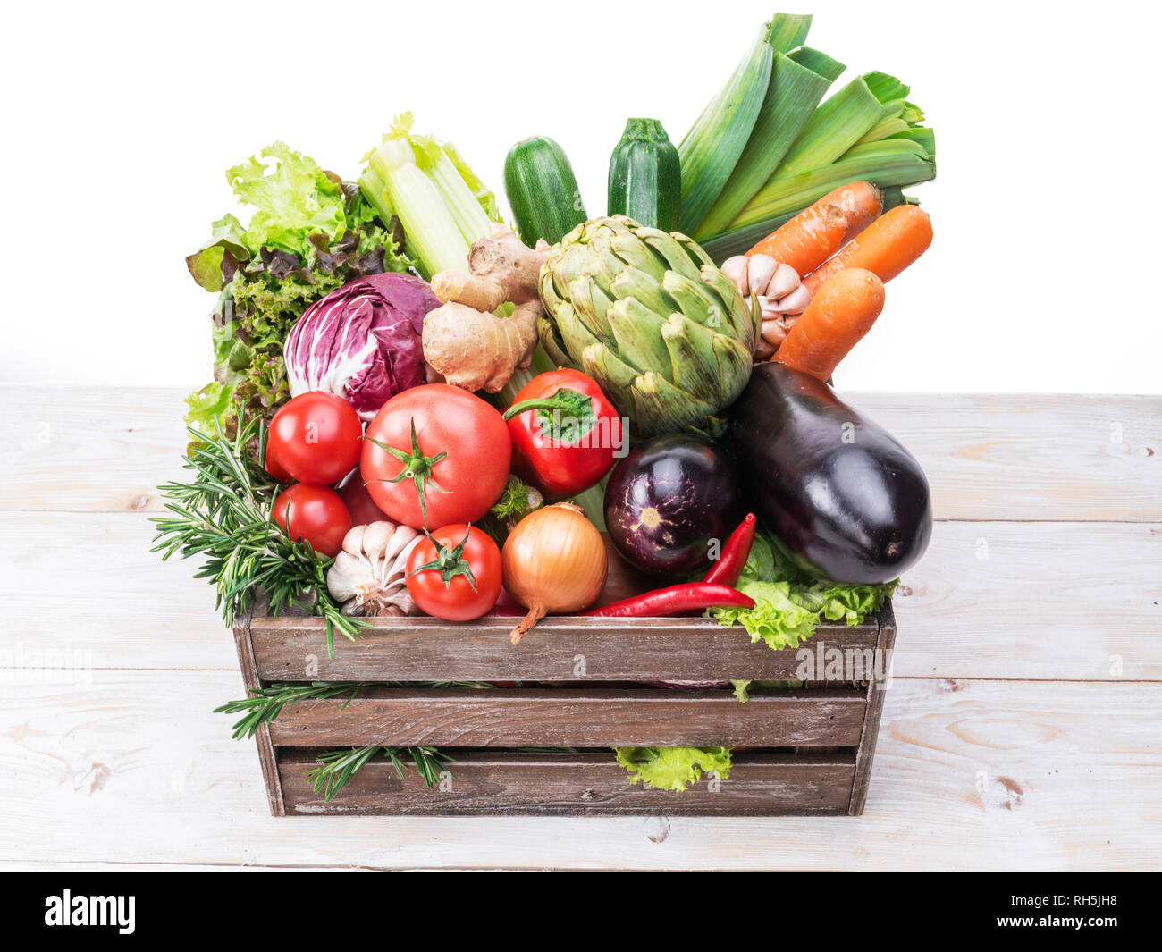 Fresh multi-colored vegetables in wooden crate. White background Stock ...