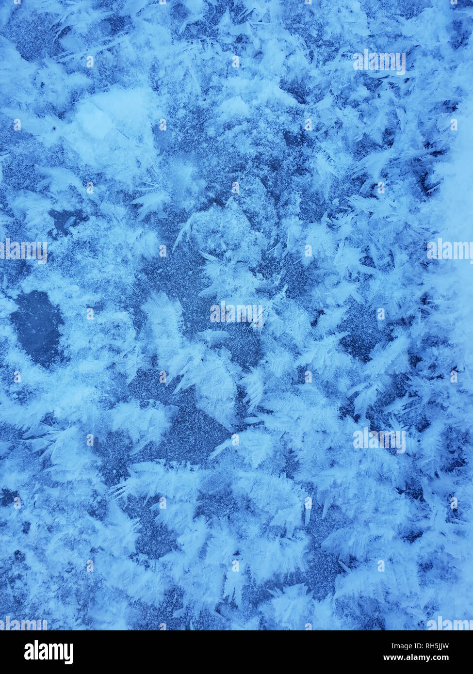 Snow crystals form beautiful snow pattern on frozen river. Snowflake ...