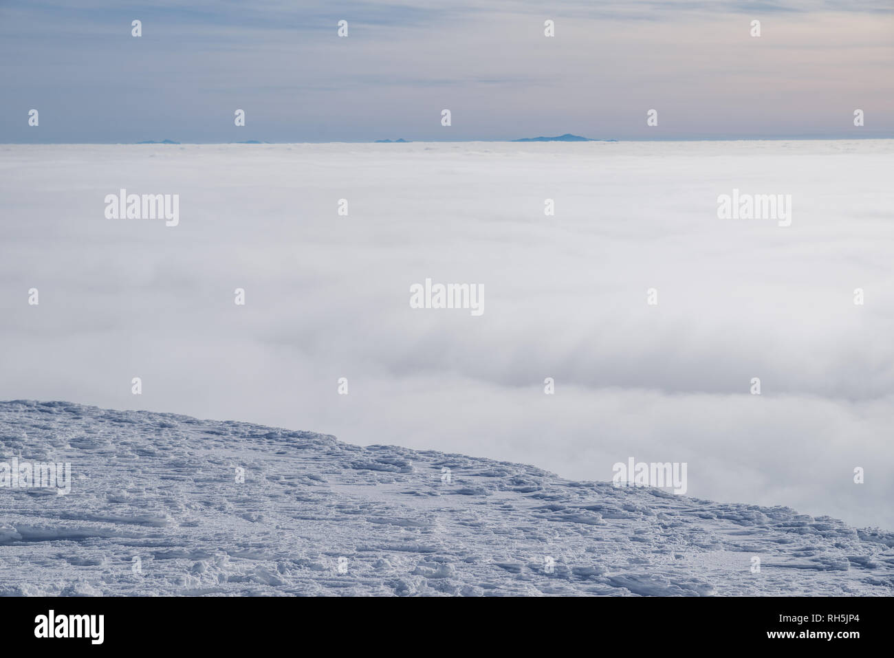 Mountain tops covered with snow above the white heavy clouds Stock ...