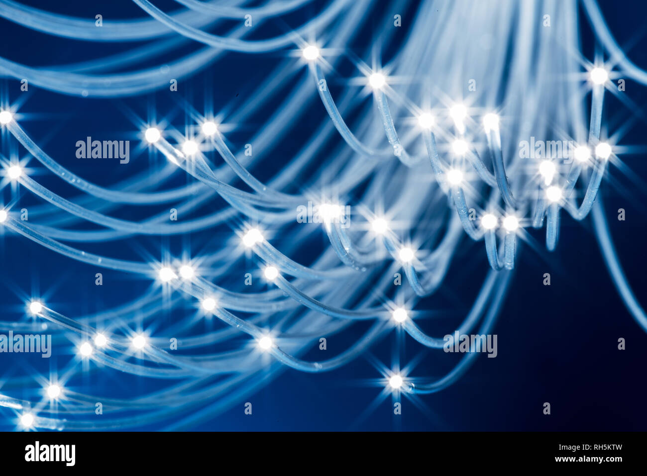 Bundle of optical fibers with lights in the ends. Blue background Stock ...