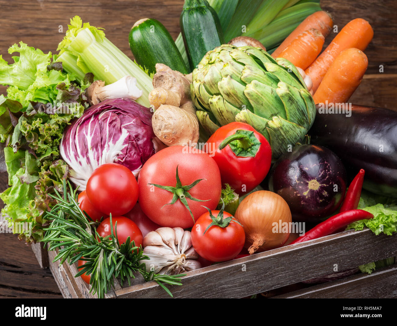 Fresh multi-colored vegetables in wooden crate. Top view Stock Photo ...
