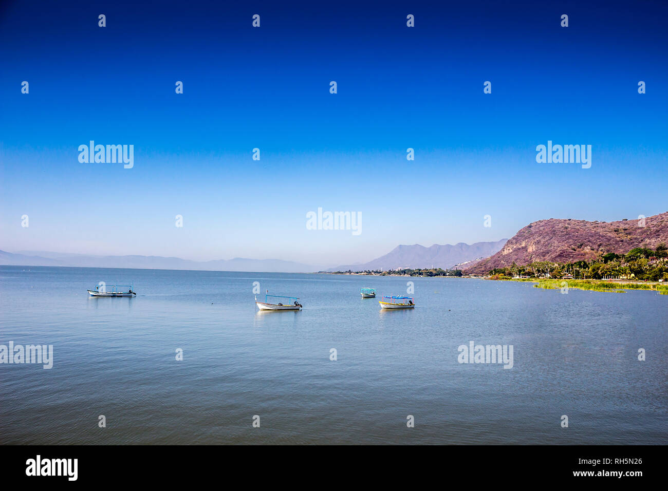 Beautiful image of motorboats on the lake of Chapala with a blue sky on ...