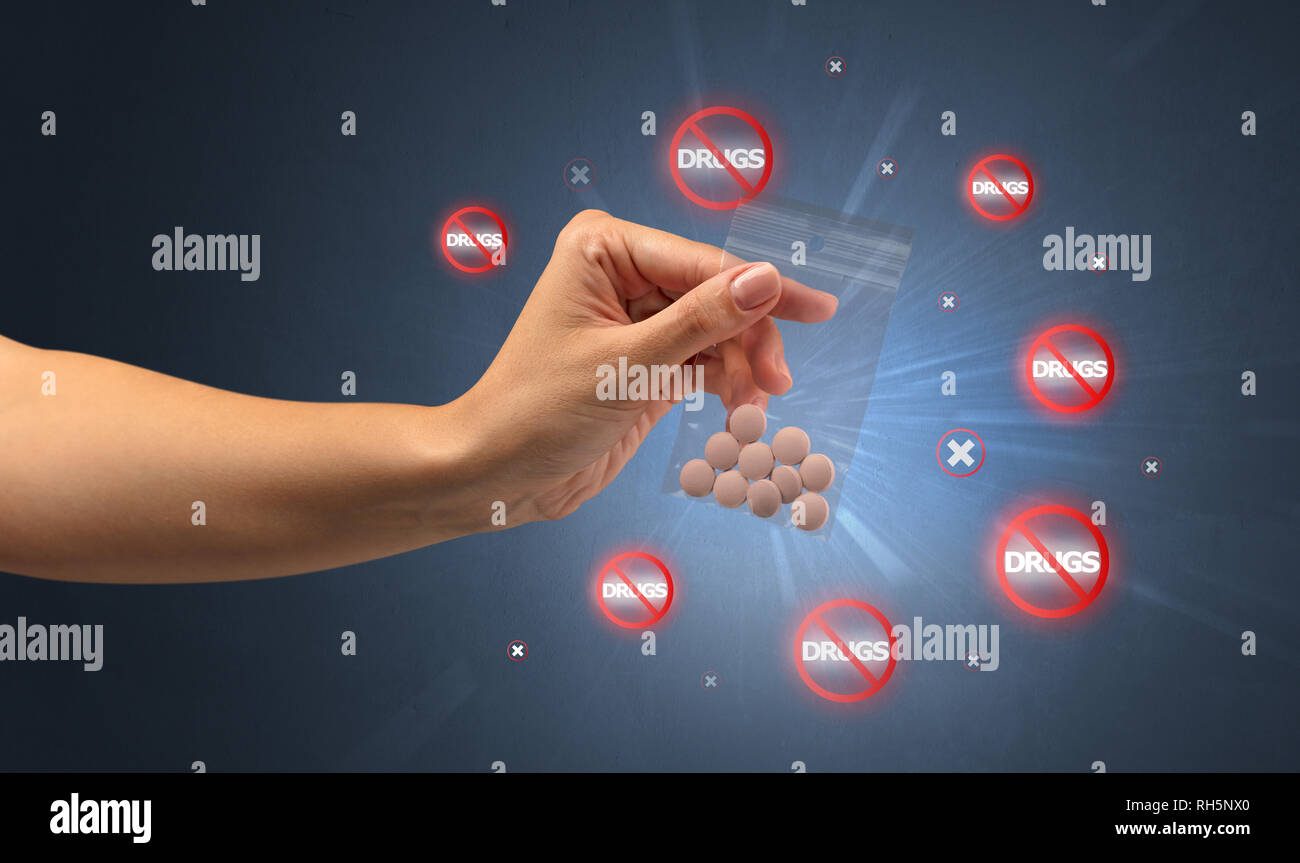 Hand giving pills with anti-drug concept and not allowed signs around ...