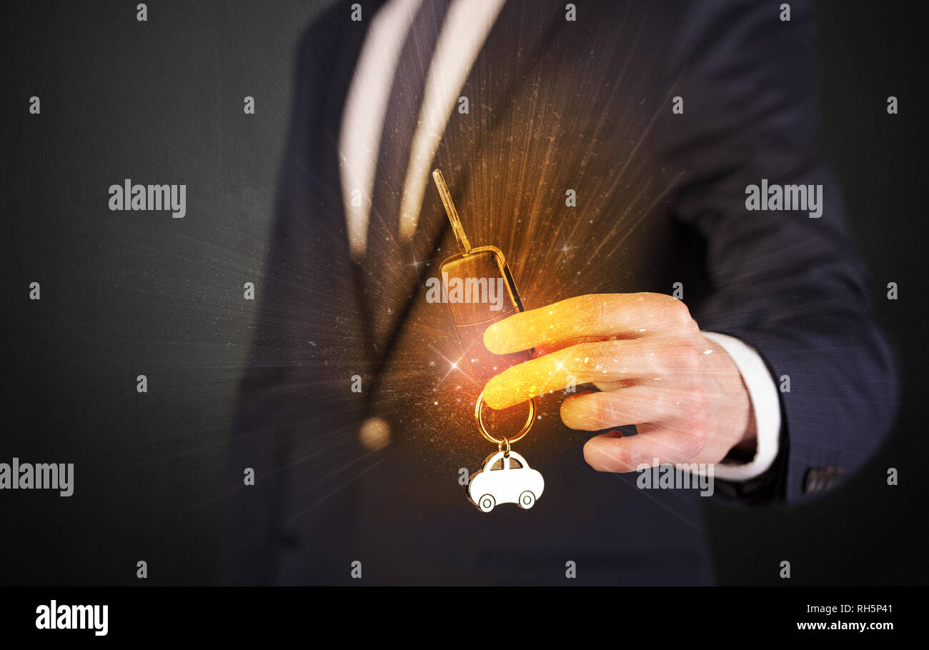 Formal man hand over shiny keys with dark background Stock Photo - Alamy