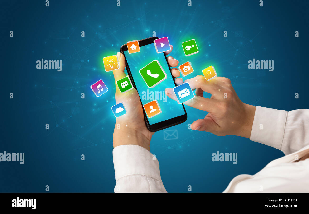Female hand using smartphone with 3D shiny starlike application icons ...