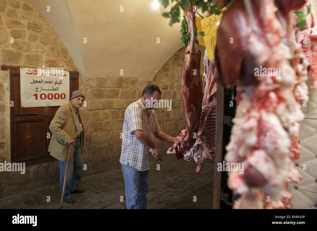 Sidon, Lebanon. 01st Feb, 2019. A Lebanese butcher cuts meat hanged up ...