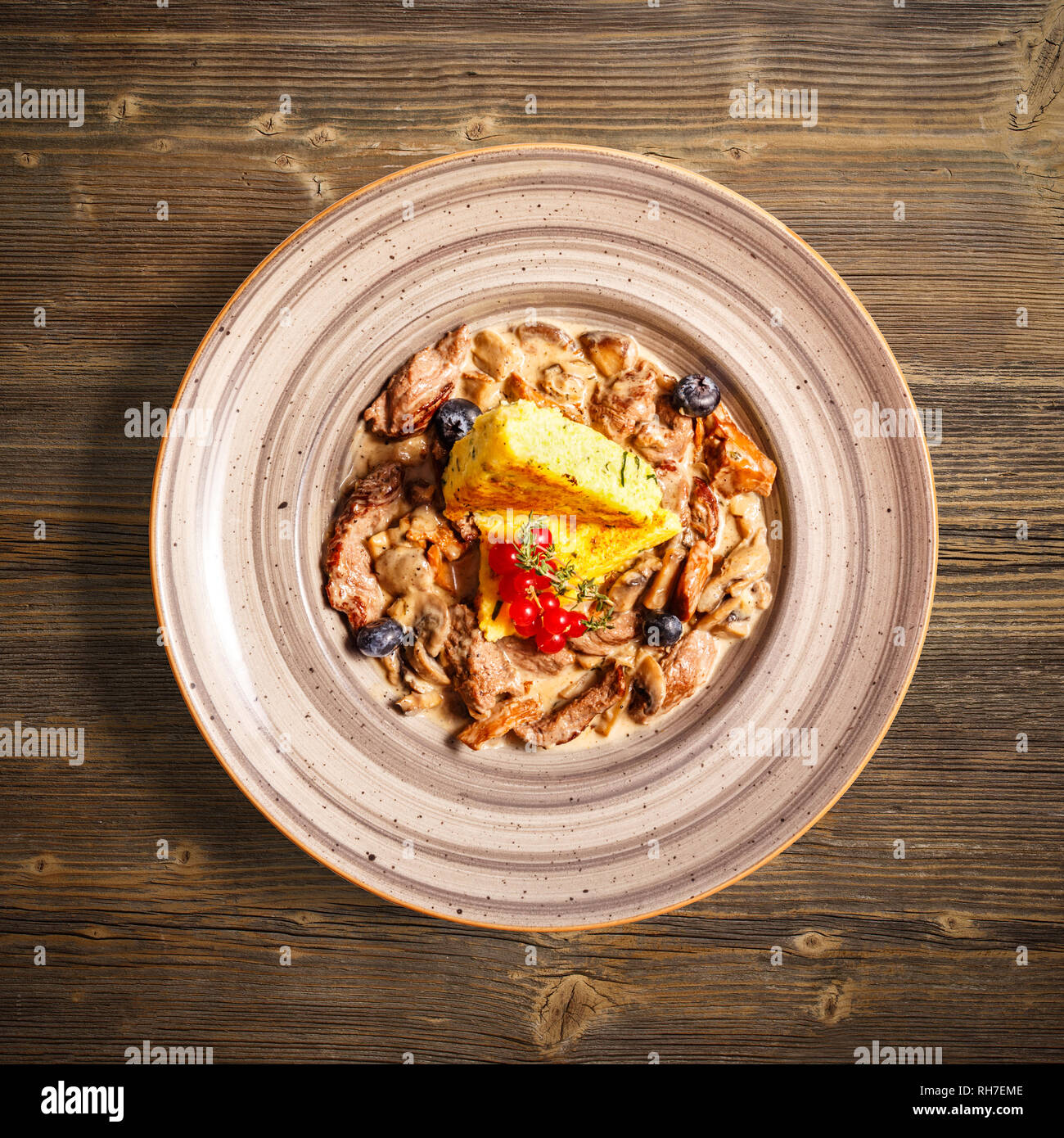 Flat lay of beef tenderloin stew with roasted polenta on wooden ...