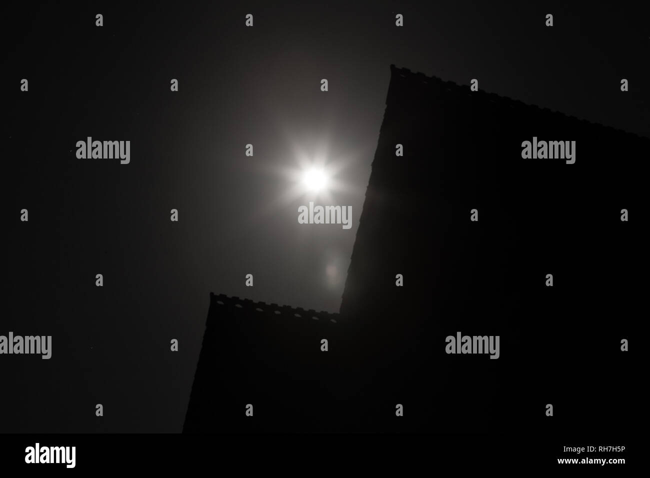 Bright moon shining over the edge of a church roof at night Stock Photo ...