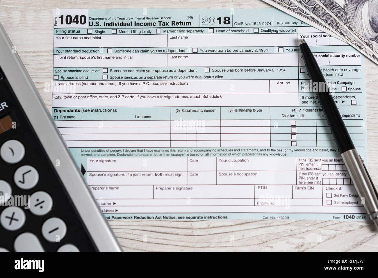US tax form 1040 with pen, calculator and dollar bills. tax form law ...