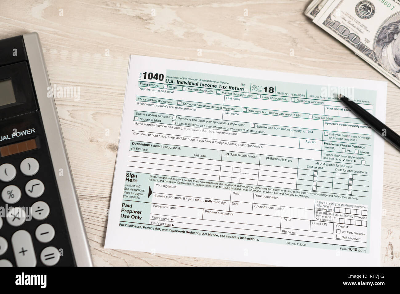 US tax form 1040 with pen, calculator and dollar bills. tax form law ...