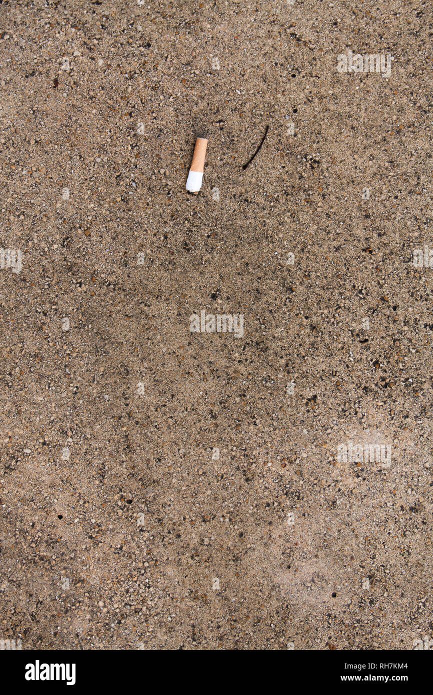 Stamped out cigarette butt on pavement or sidewalk Stock Photo - Alamy