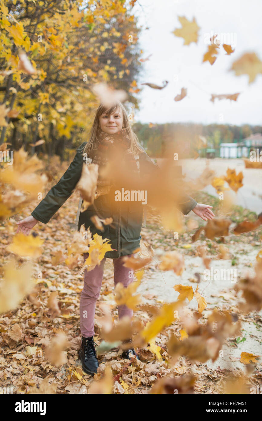 Playful tween girl playing in autumn leaves in park Stock Photo - Alamy